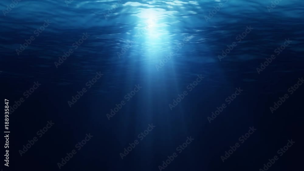 Sunlight rays shining through ocean surface. Dark blue underwater ...