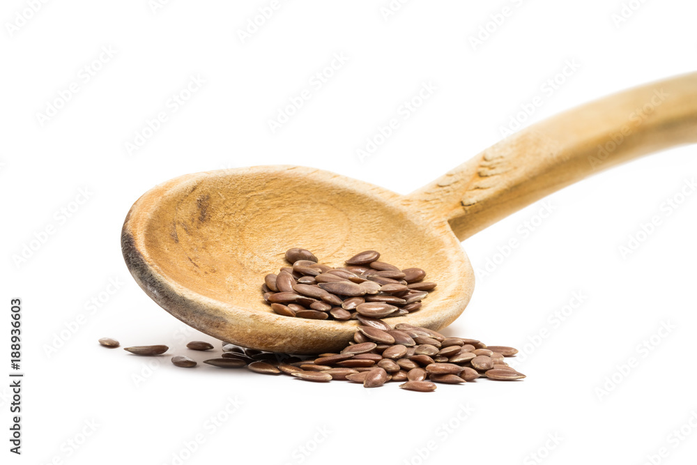 Linseed or flax seed on a tilted wooden spoon seen low angle isolated on white background Stock ...
