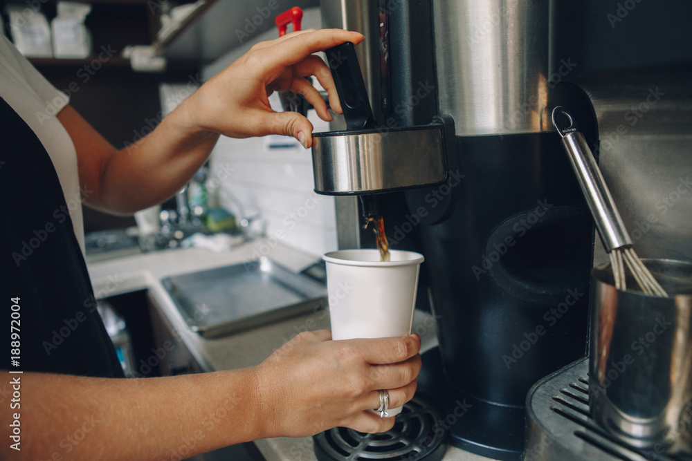 Young Caucasian barista hands holding paper cup making coffee using ...