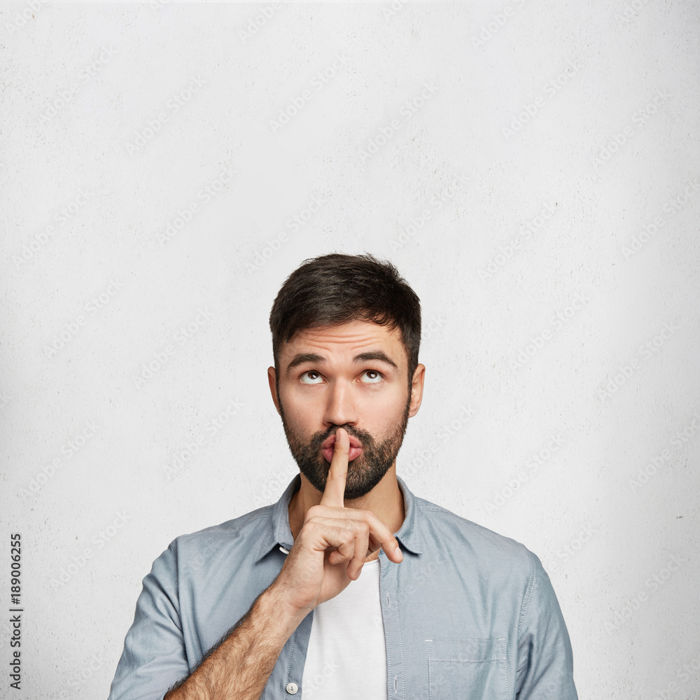 Vertical shot of secret handsome male student asks to keep silence ...