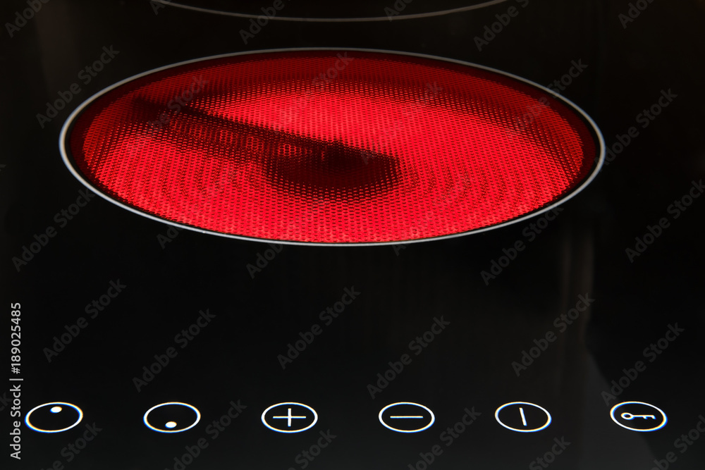 Modern induction cooker with control buttons. The electric hob closeup ...