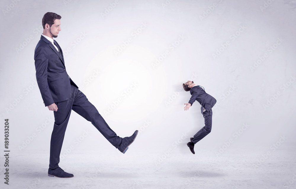 Big man kicking little himself out Stock-Foto | Adobe Stock