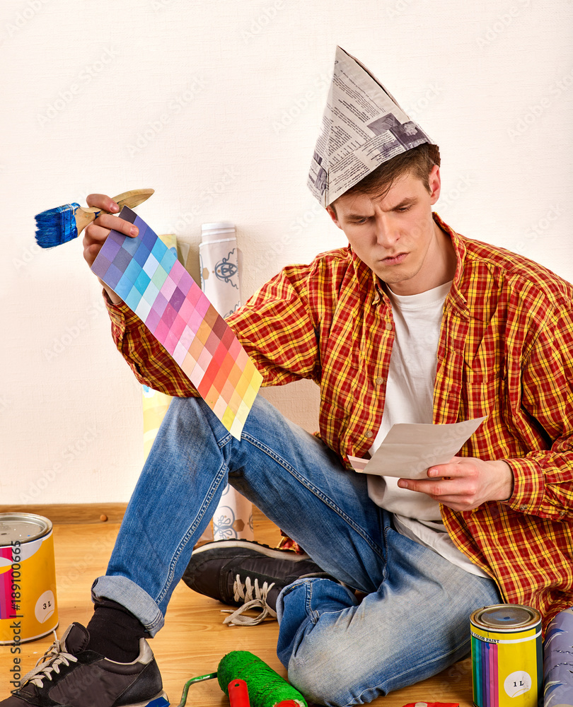 Repair man holding paint brush for wallpaper. Tired and frustrated mad ...