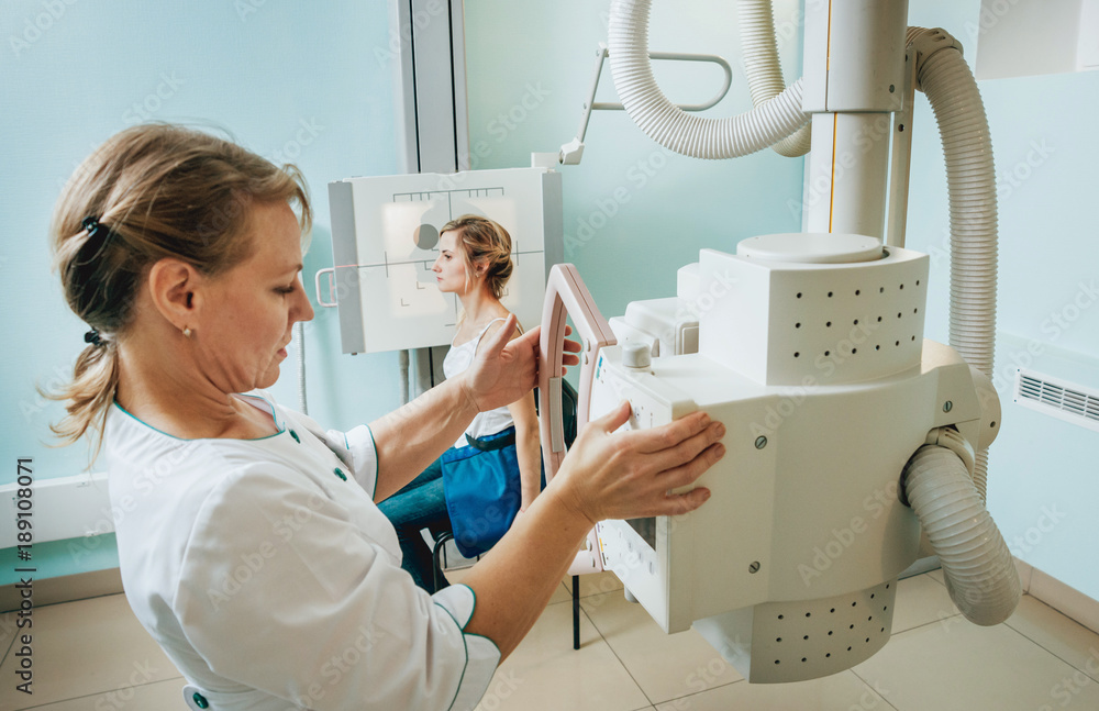 Radiologist and patient in a x-ray room. Classic ceiling-mounted x-ray ...