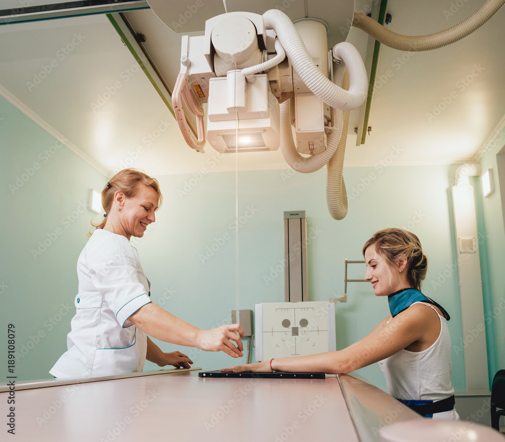Radiologist and patient in a x-ray room. Classic ceiling-mounted x-ray ...