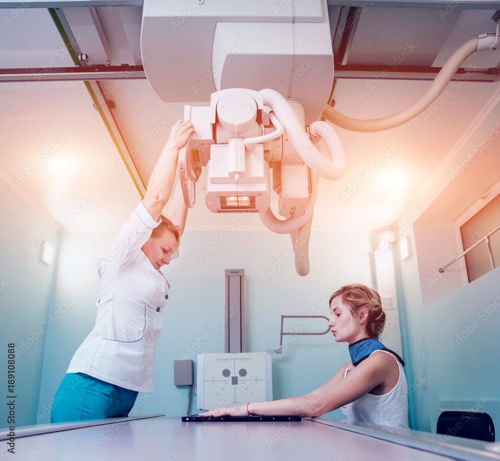 Radiologist and patient in a x-ray room. Classic ceiling-mounted x-ray ...