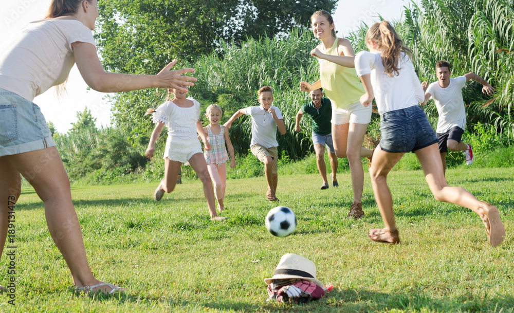 Group of happy people with children outdoors playing football Stock ...