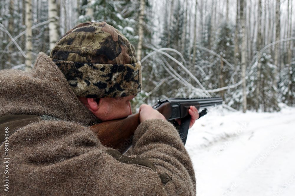 A hunter with a gun. Winter hunting. Huntsman. Stock Photo | Adobe Stock