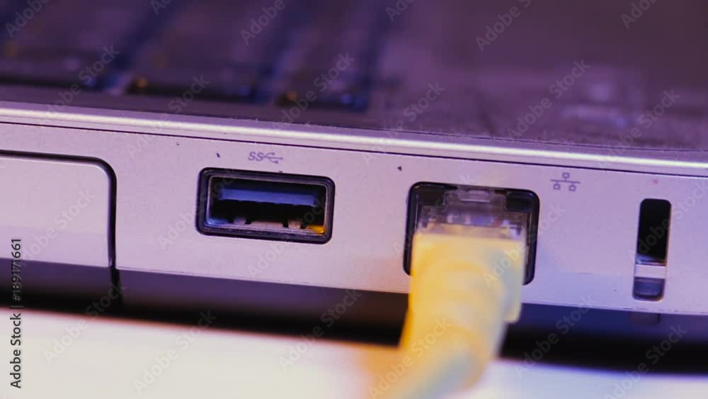 Closeup of Ethernet cable plug inserted into port on the side of a ...