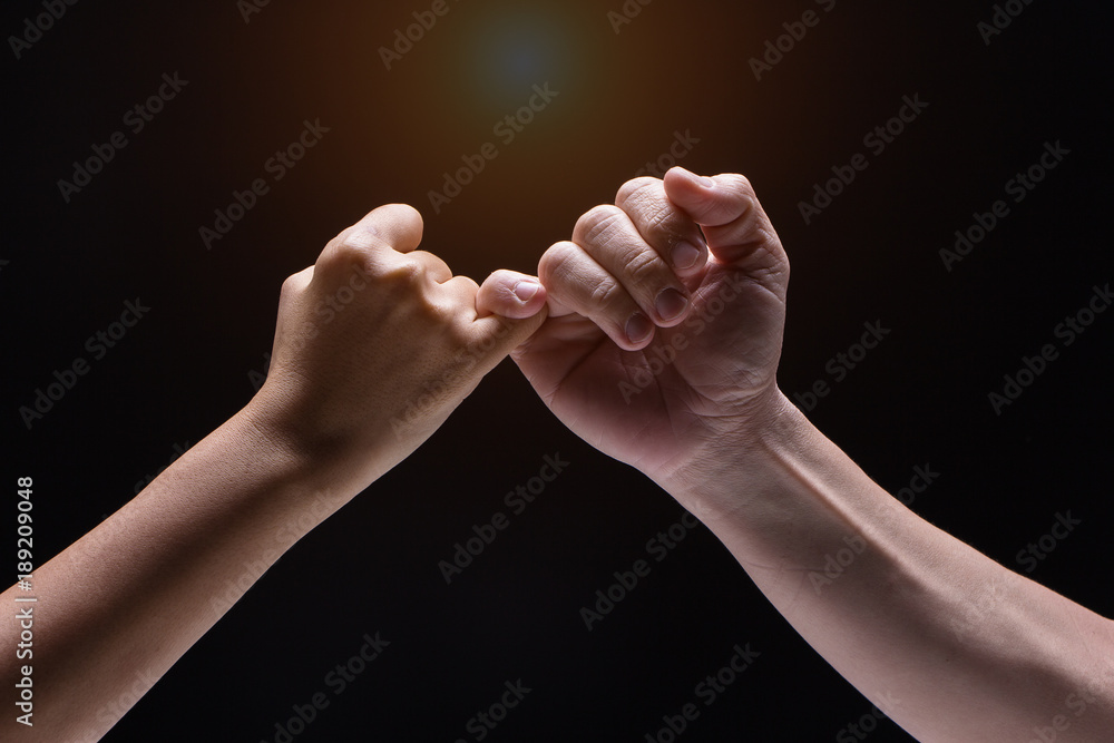 Closeup human hand ,Hook each other's little finger,on black background ...