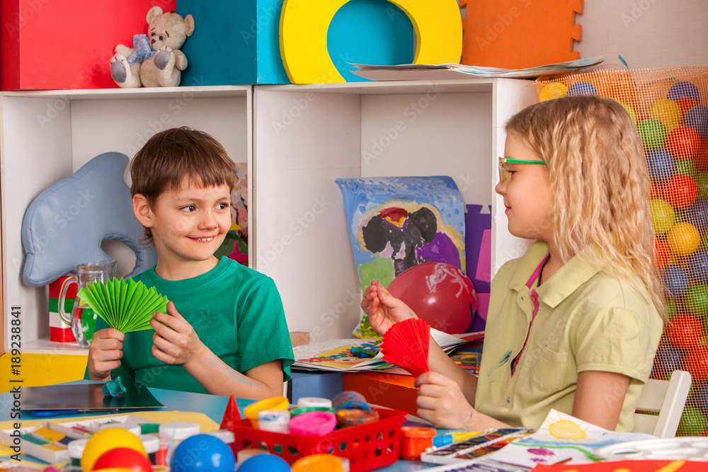School children with paper in kids hands with teacher in class room ...