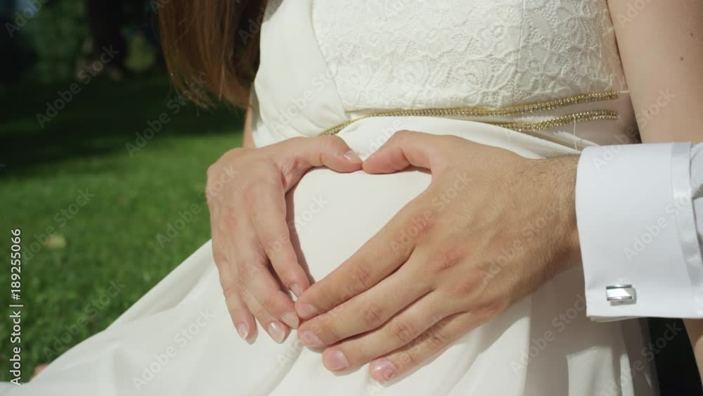 SLOW MOTION, CLOSE UP: Young couple forming a heart shape with hands ...