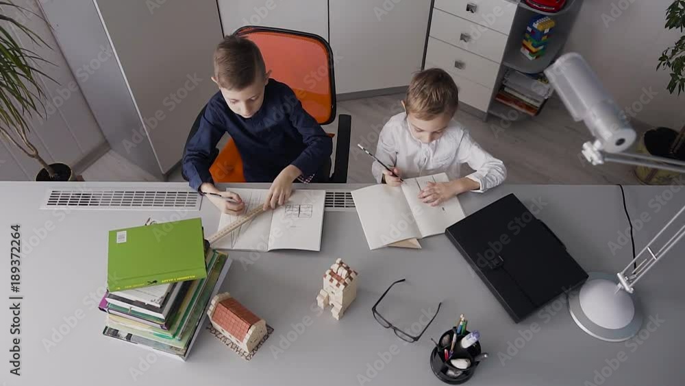 Two students do homework at home. The guys draw designs for houses that ...