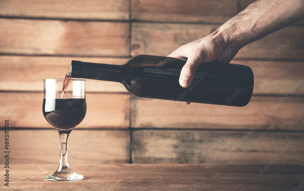 Hand Pouring Glass Of Wine