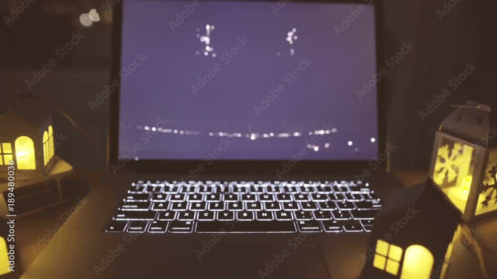 Winter holidays. Sliding video of opened laptop with fireworks on ...