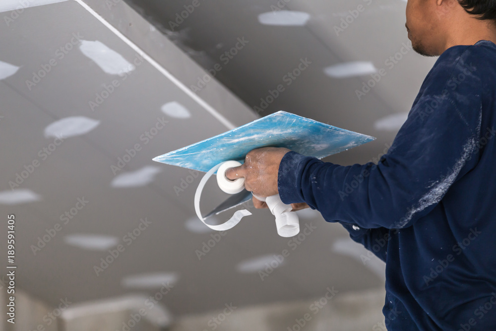 Construction man worker plaster gypsum ceiling for interior build ...