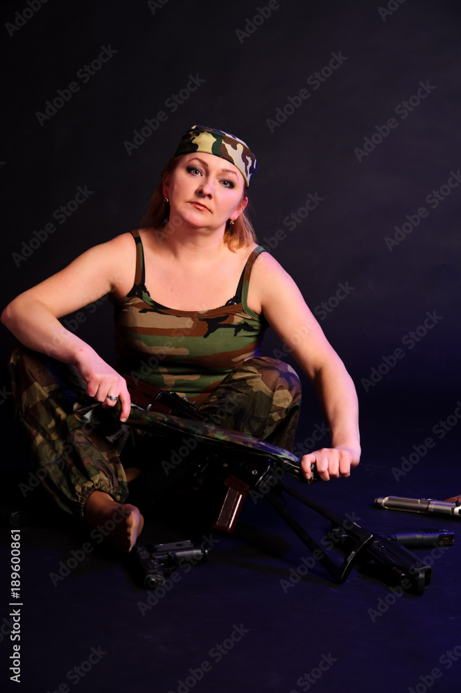 Foto de A middle aged, white, woman holds an AK47 automatic rifle, with ...