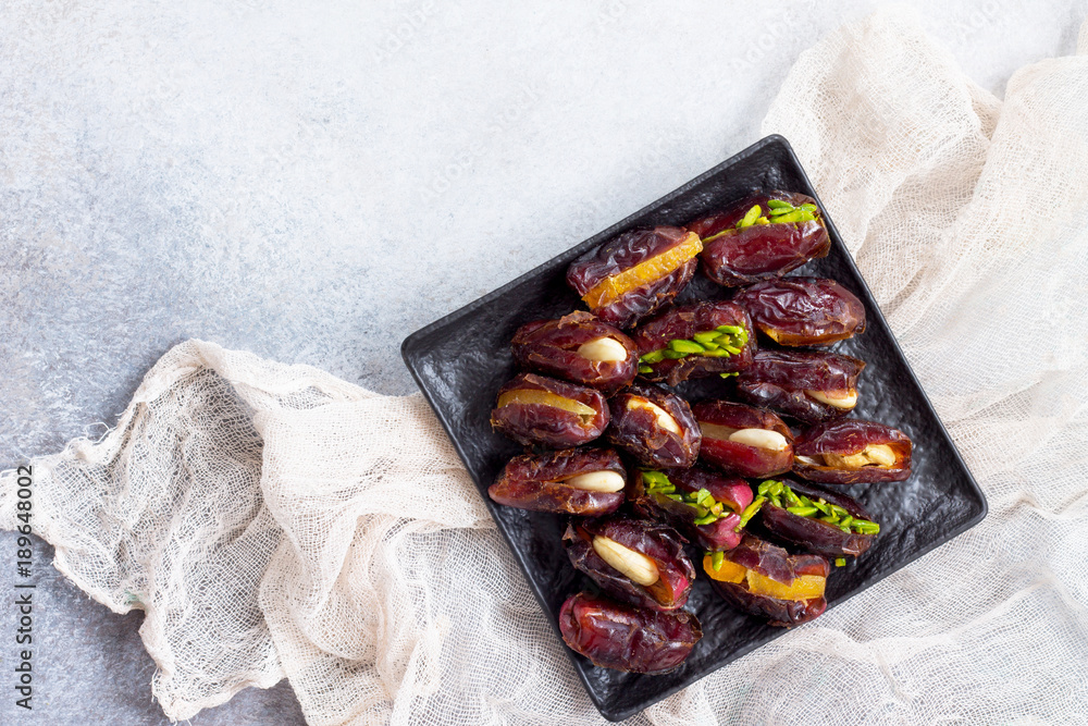 Stuffed dates with nuts and candied fruit filling on a stone or slate ...