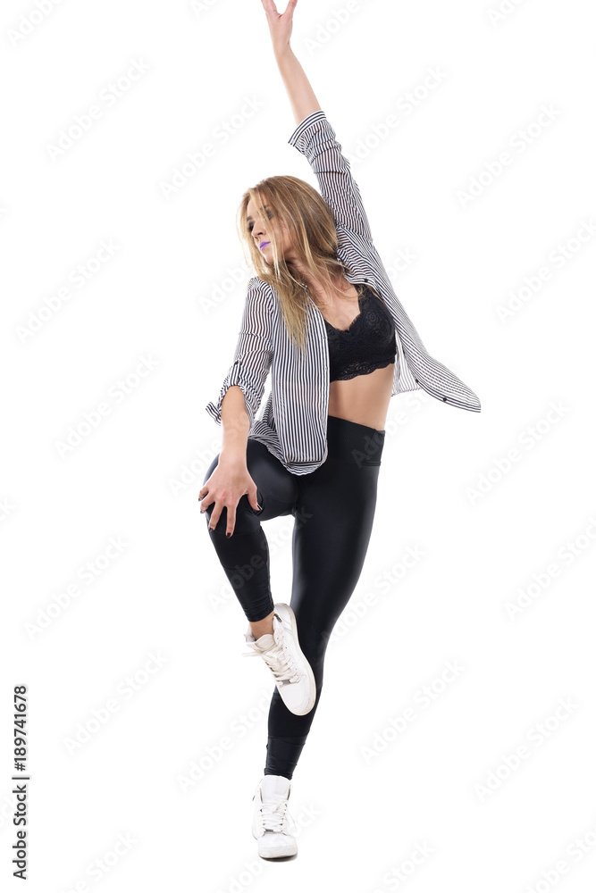 Graceful attractive blonde woman dancing in one leg with hand raised ...