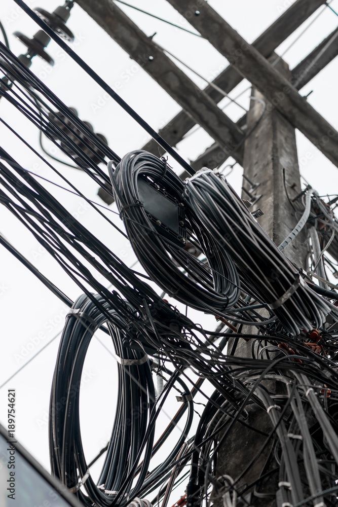picture of a close-up of randomly hanging wires on electric poles in ...