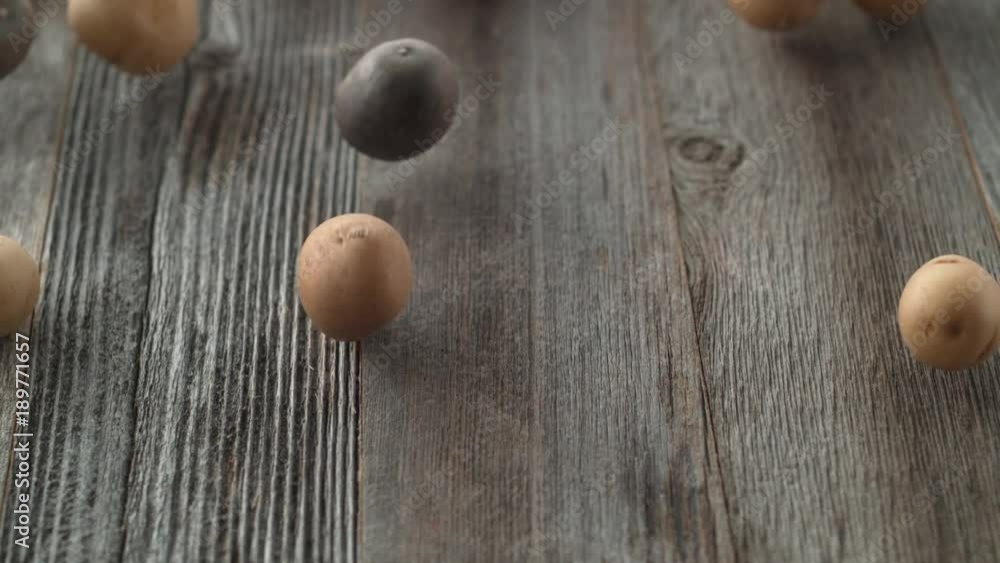 Potatoes falling and rolling on a table. Shot with high speed camera ...