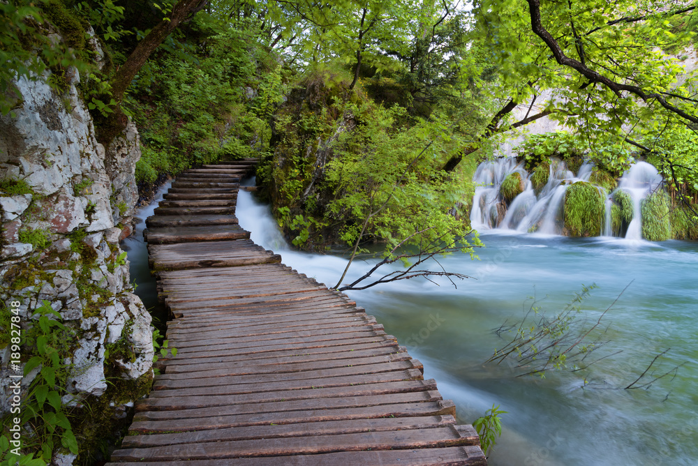 Beautiful view of waterfalls with turquoise water and wooden pathway ...