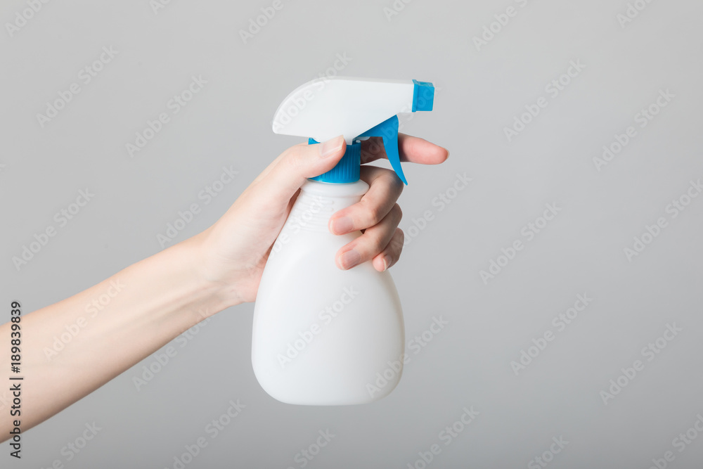 Hand holding a spray bottle. Stock Photo | Adobe Stock