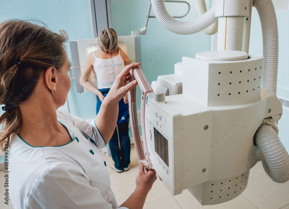 Radiologist and patient in a x-ray room. Classic ceiling-mounted x-ray ...
