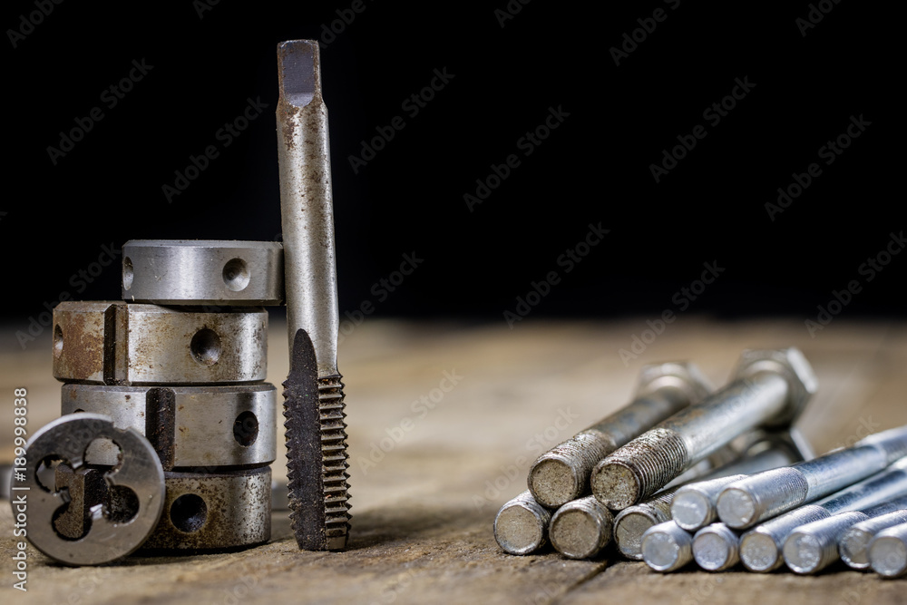 Metalwork tools on the workshop table. Threading dies and taps in an ...