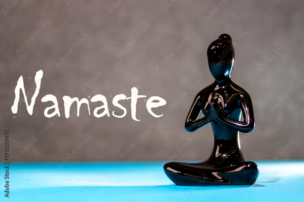 Little black figurine woman keep hands in Namaste - greeting sign. Yoga ...