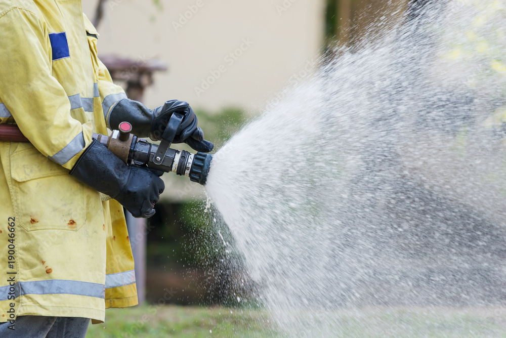 Firefighter holding high pressure fire hose nozzle. Firefighters ...