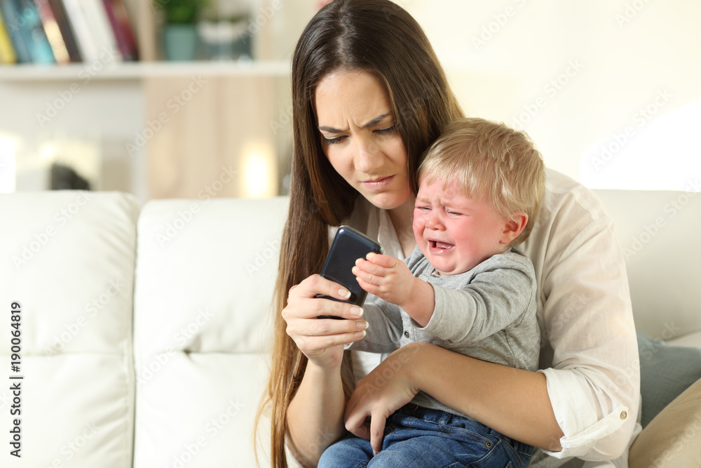 Baby tantrum fighting with his mother for a smart phone Stock Photo ...