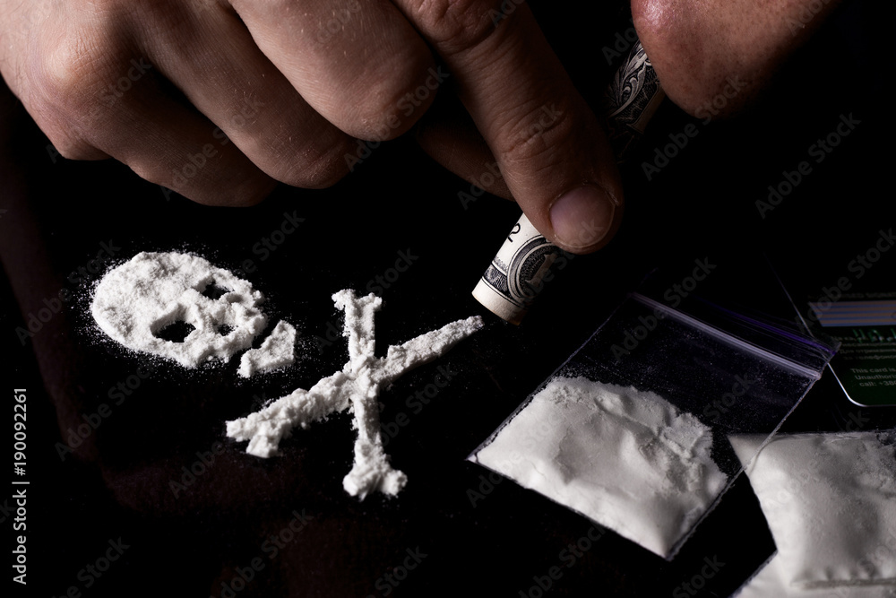 Drug dependence Kills. Junkie man sniffing a line of cocaine in the ...