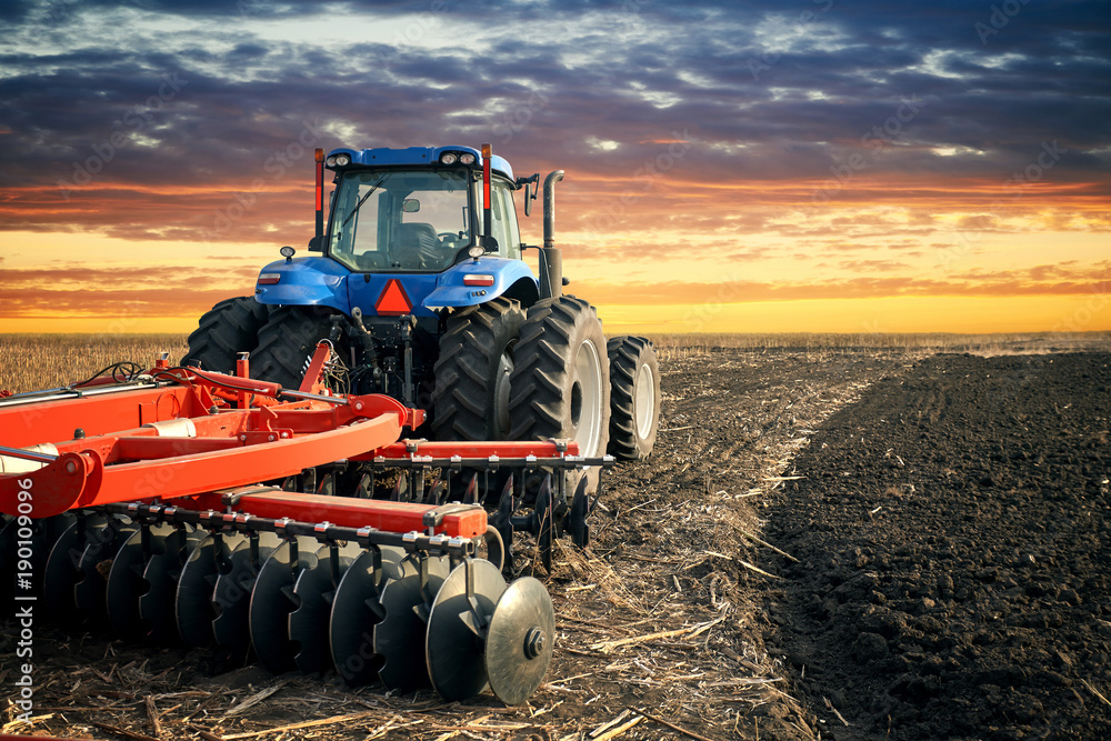 Tractor plowing field on sunset background Stock Photo | Adobe Stock Tractor plowing field on sunset background Stock Photo | Adobe Stock