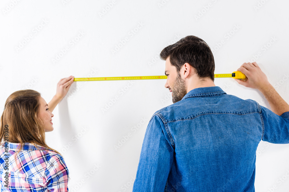 girlfriend and boyfriend measuring wall with tape measure Stock Photo ...