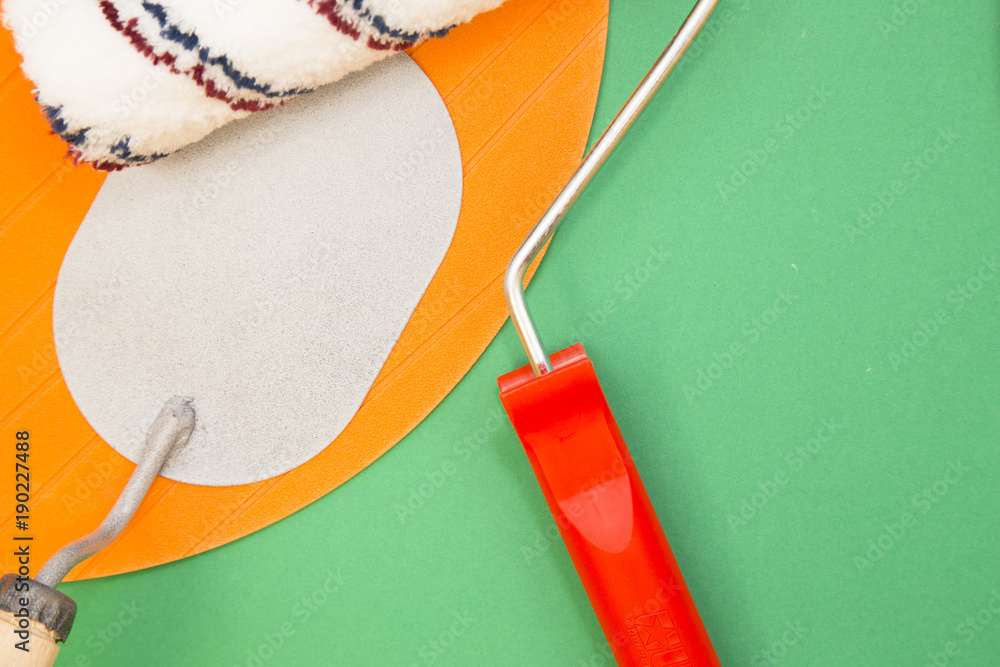 Wall painting Concept. A paint roller and a float on a bright orange ...