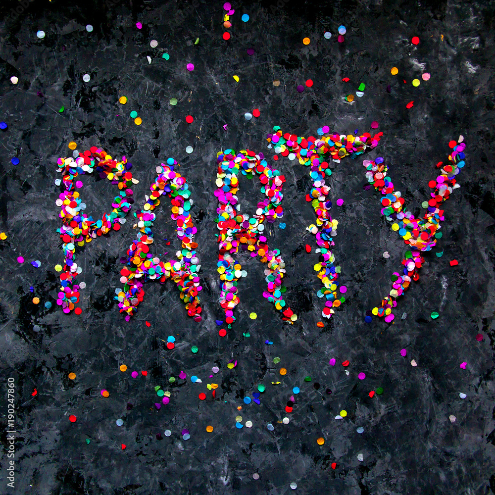 Word 'party' made of colorful confetti on black textured background ...