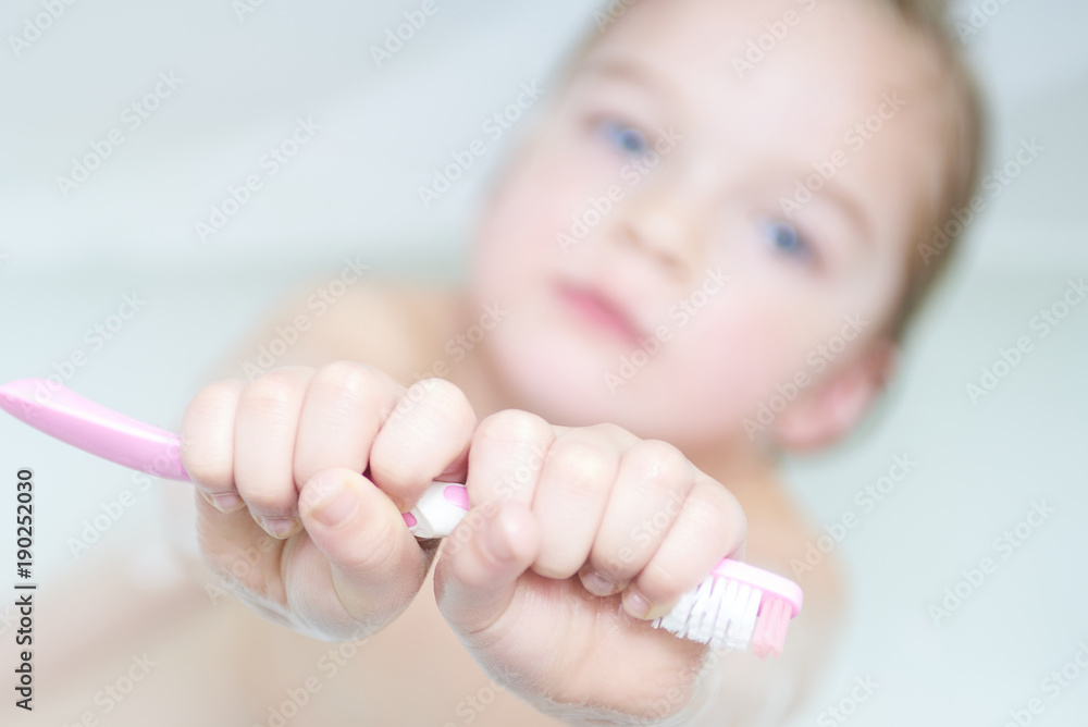 Cute smiling little girl is taking a bath holding toothbrush Stock ...