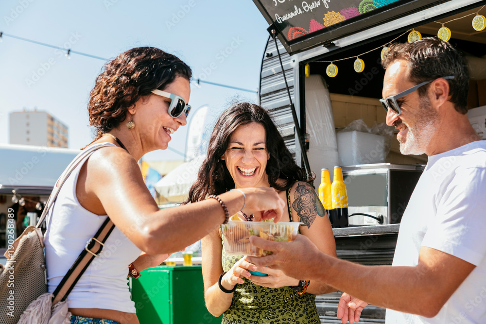 People eating snacks at food truck Stock Photo | Adobe Stock