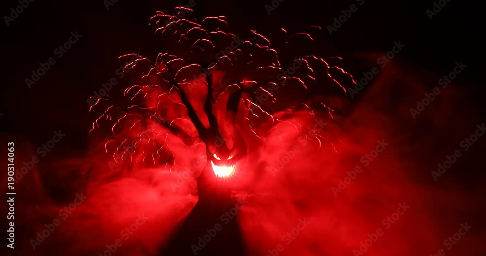 Silhouette of scary Halloween tree with horror face on dark foggy toned ...