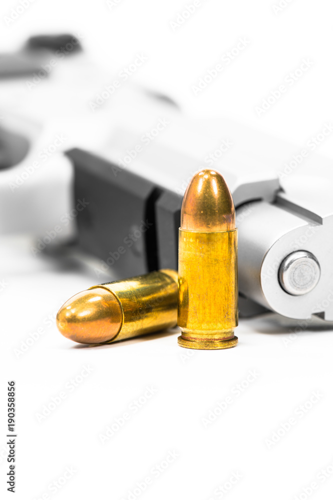 Bullets and guns are placed on white ground. Stock Photo | Adobe Stock