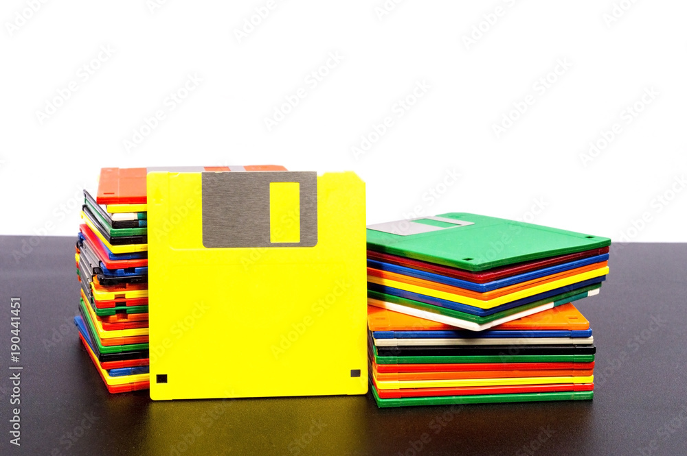 Horizontal shot of two stacks of old plastic disks with a yellow disk ...