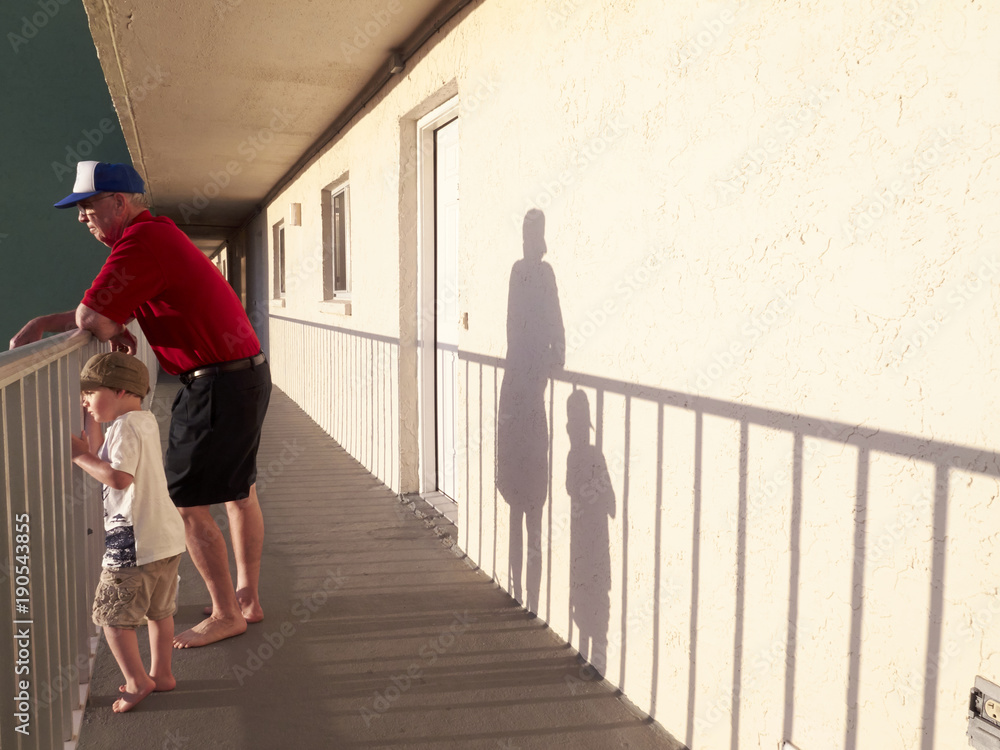 Grandpa and grandson looking over balcony Stock Photo | Adobe Stock