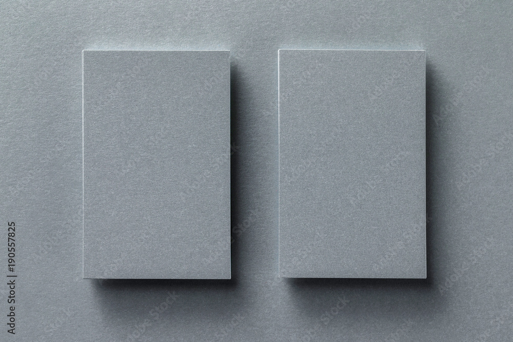 Mockup of two vertical silver metallic business card stacks at textured ...