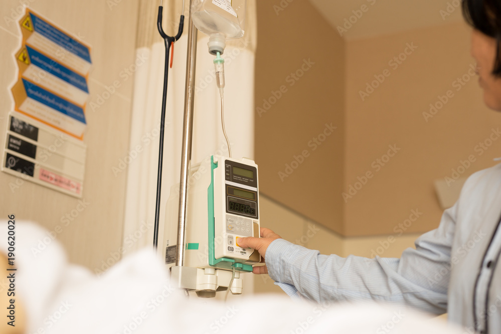 Doctor 's hand control IV on infusion pump intravenous IV drip in ...