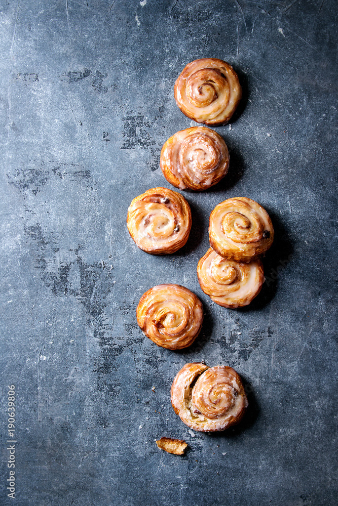 Homemade glazed puff pastry cinnamon rolls with custard and raisins ...