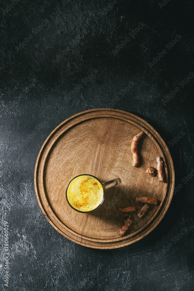 Cup of ayurvedic drink golden milk turmeric latte with curcuma powder ...