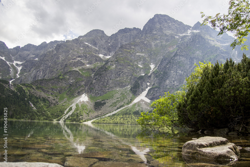 Reflection of Tatra mountain peaks in Morskie Oko lake. Eye of the Sea ...