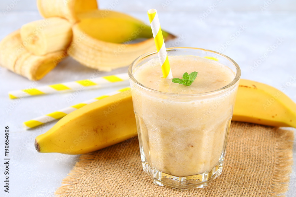 Banana smoothie with a paper tube and mint. Bananas are whole and cut ...