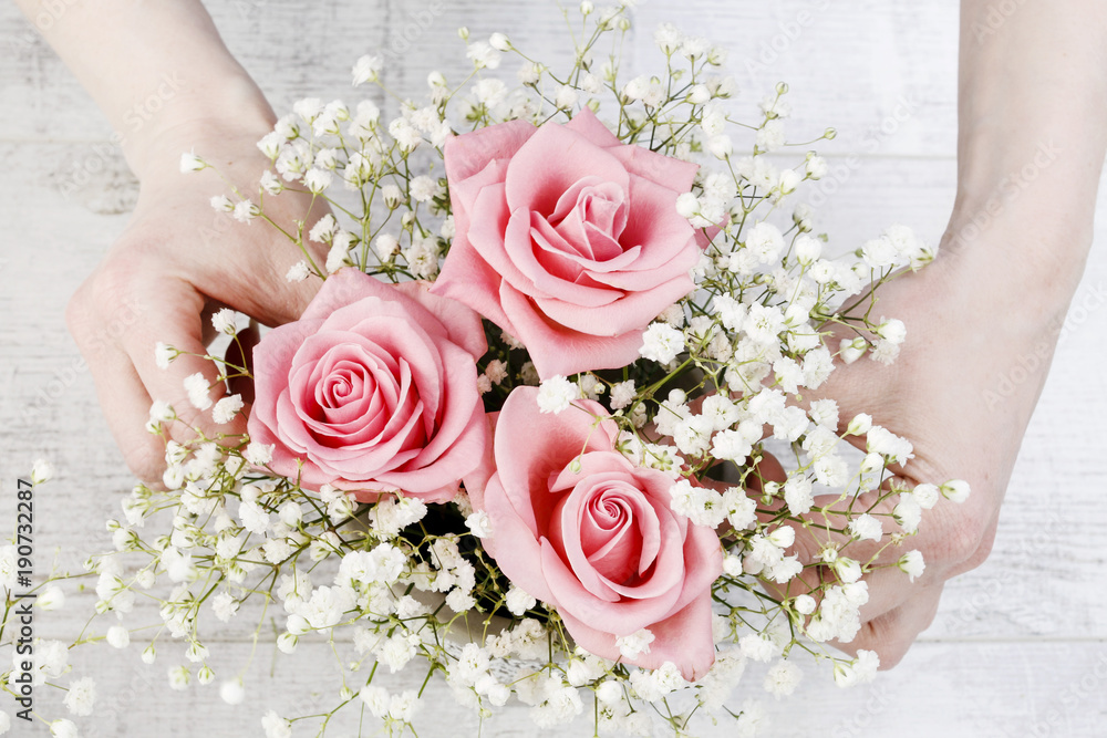 Making decorations with pink roses and white gypsophila paniculata ...